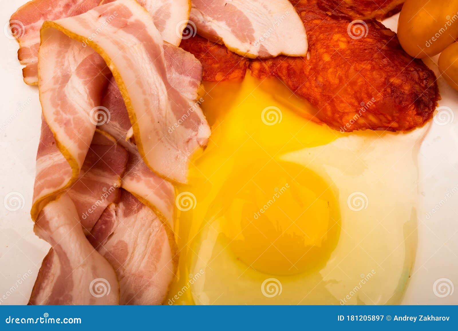 A Broken Chicken Egg without a Shell, Slices of Sausage and Bacon and ...