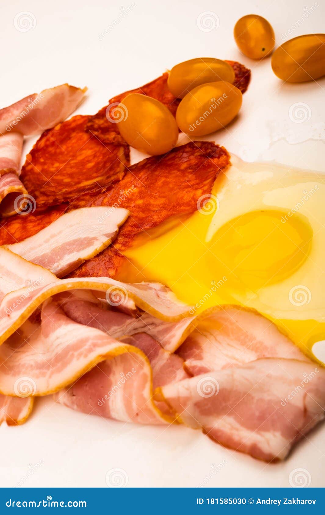 A Broken Chicken Egg without a Shell, Slices of Sausage and Bacon and ...