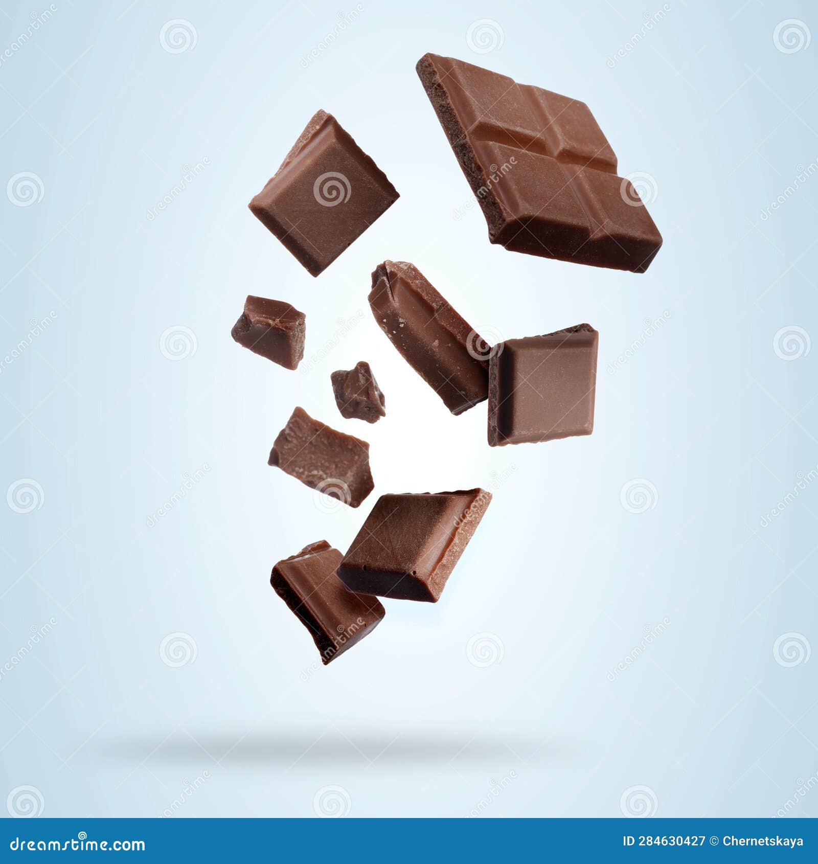 Broken Chocolate Bar Pieces Falling on Light Blue Background Stock ...