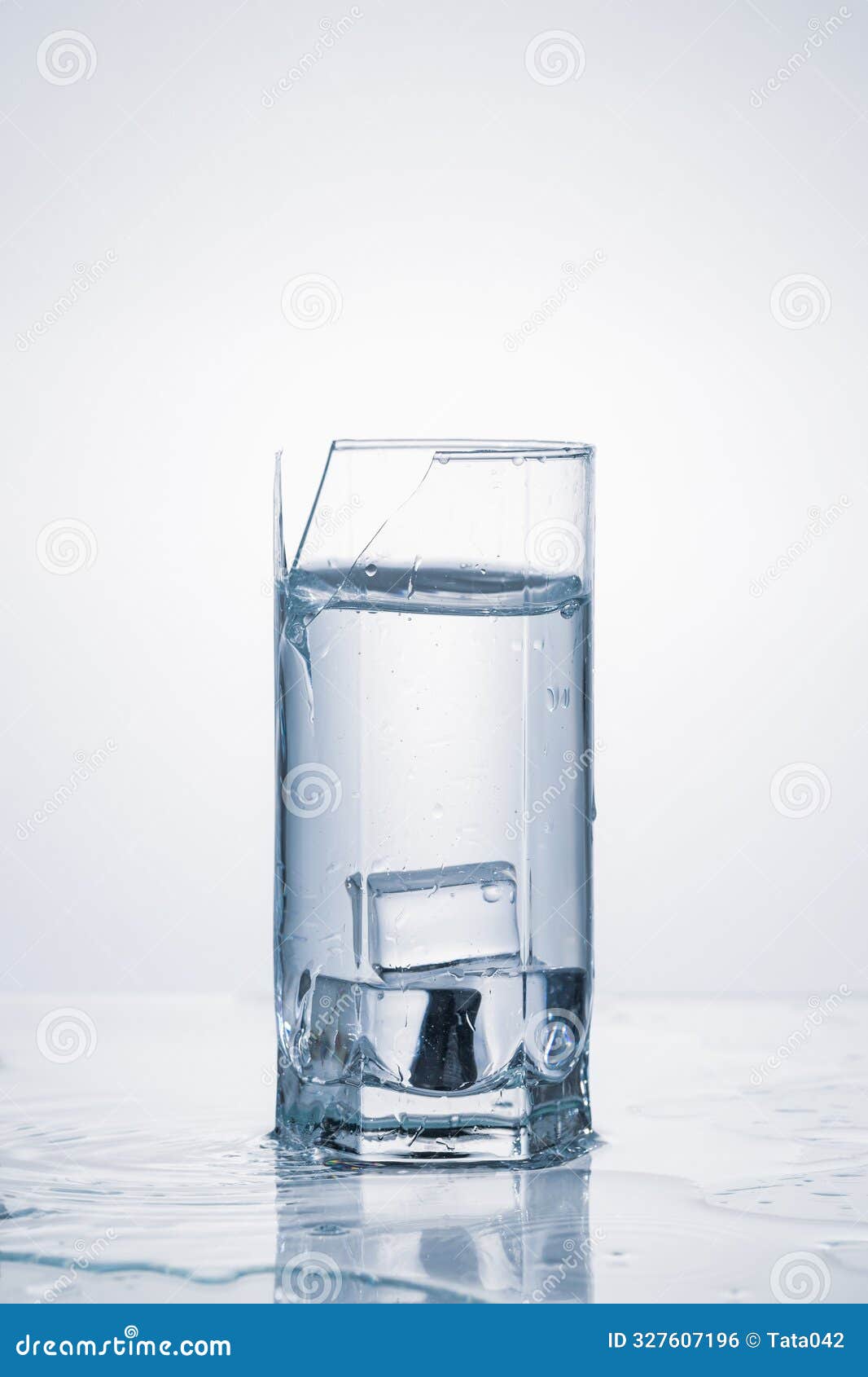 Broken Glass of Water with Ice Cube. Pouring Water from Glass on Light ...
