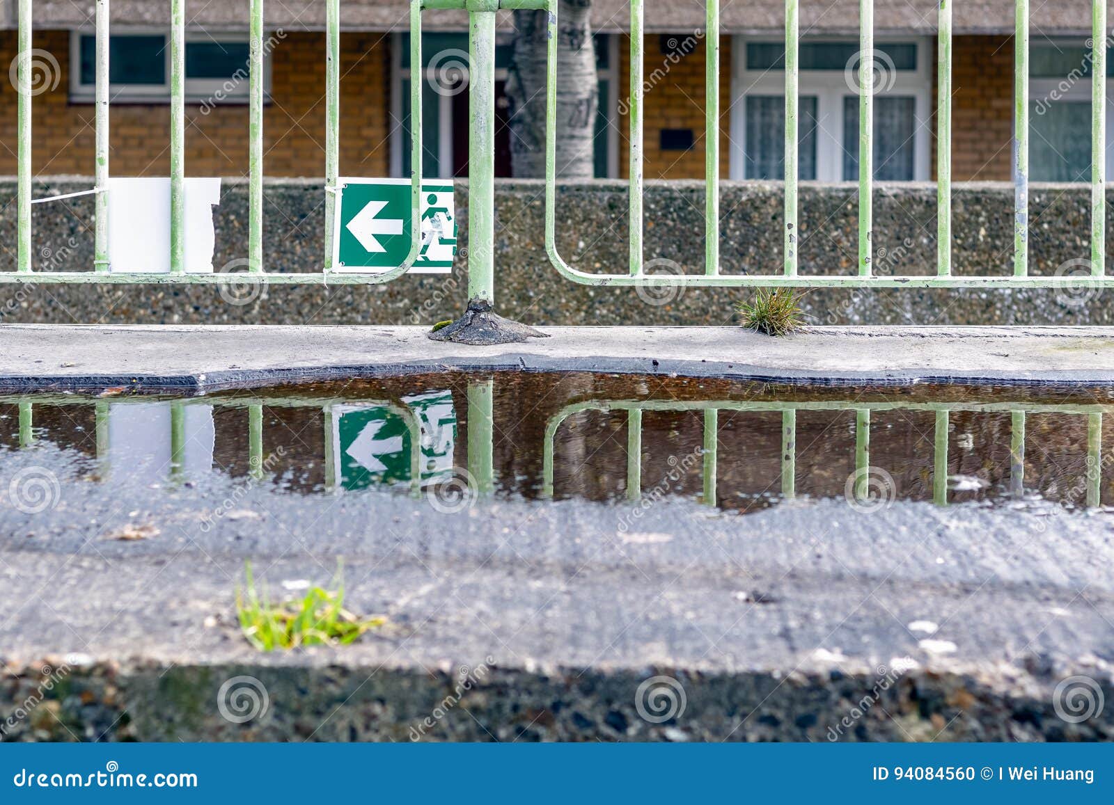 Broken Green Emergency Exit Sign and Its Reflection from a Puddle Stock ...