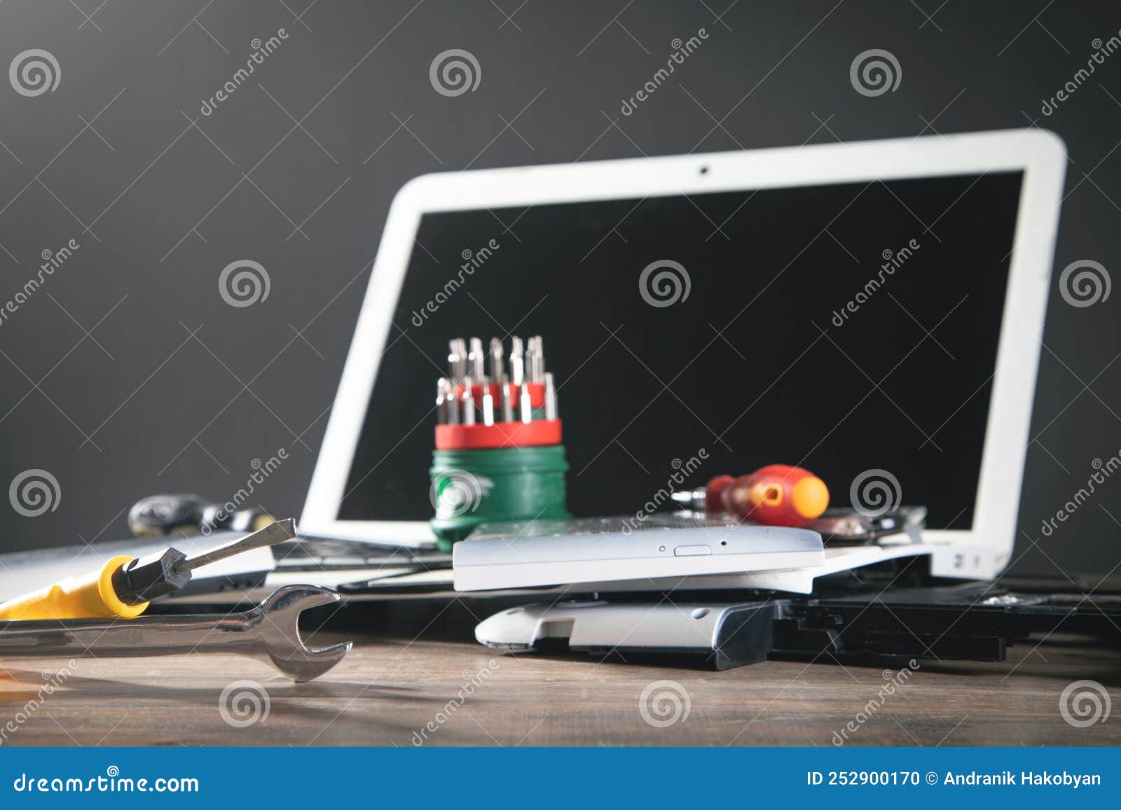 Broken Laptop with a Wrench and Screwdriver on the Table. Computer ...