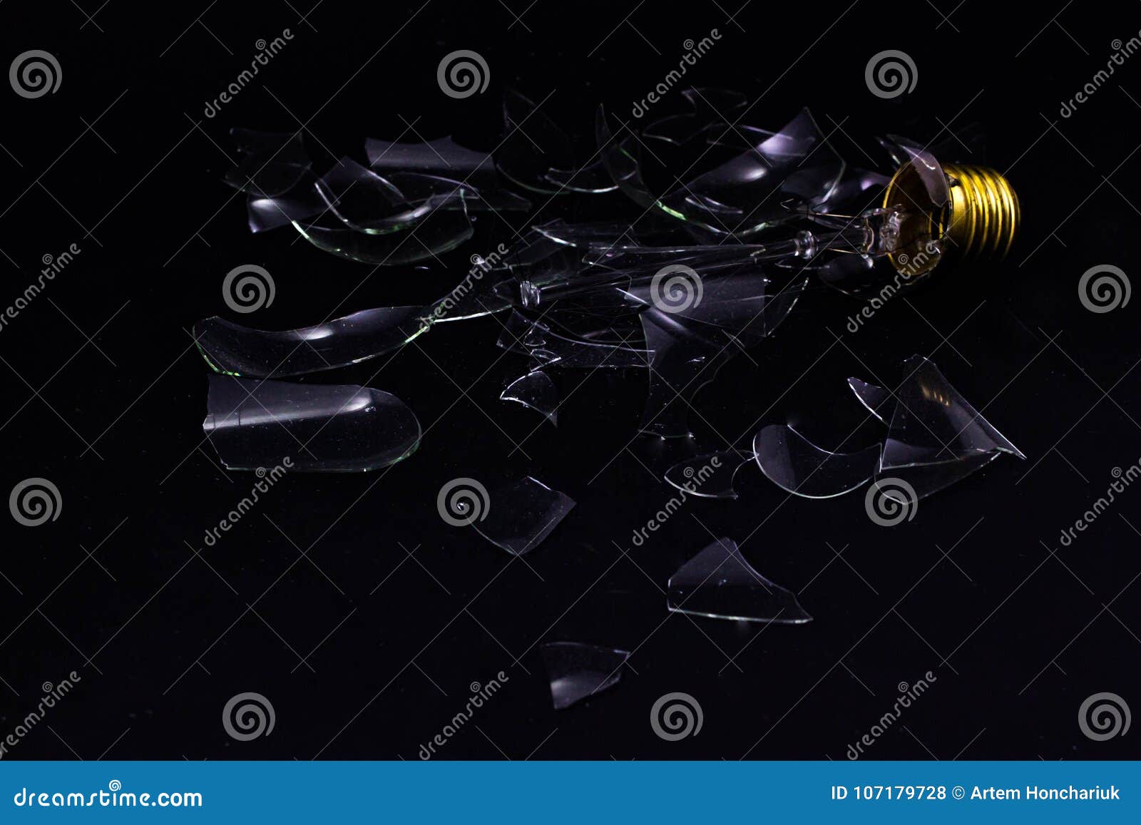 Broken Light Bulb on Dark Surface with Pieces Backlit Stock Photo ...