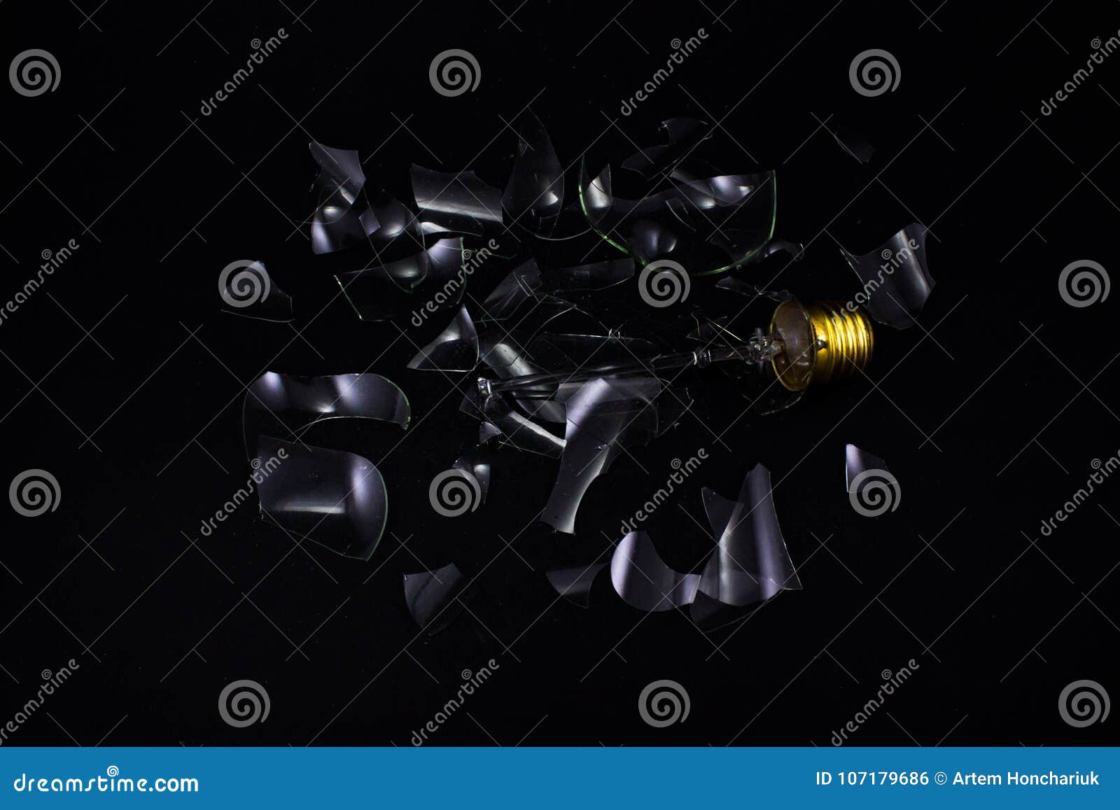 Broken Light Bulb on Dark Surface with Pieces Backlit Stock Photo ...