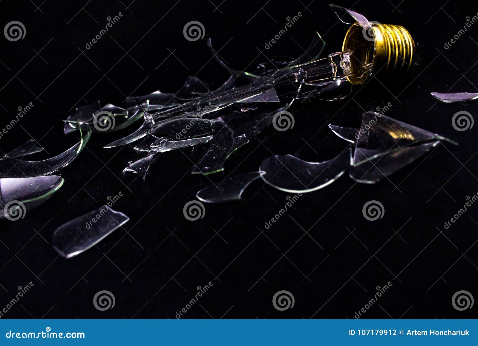 Broken Light Bulb on Dark Surface with Pieces Backlit Stock Photo ...