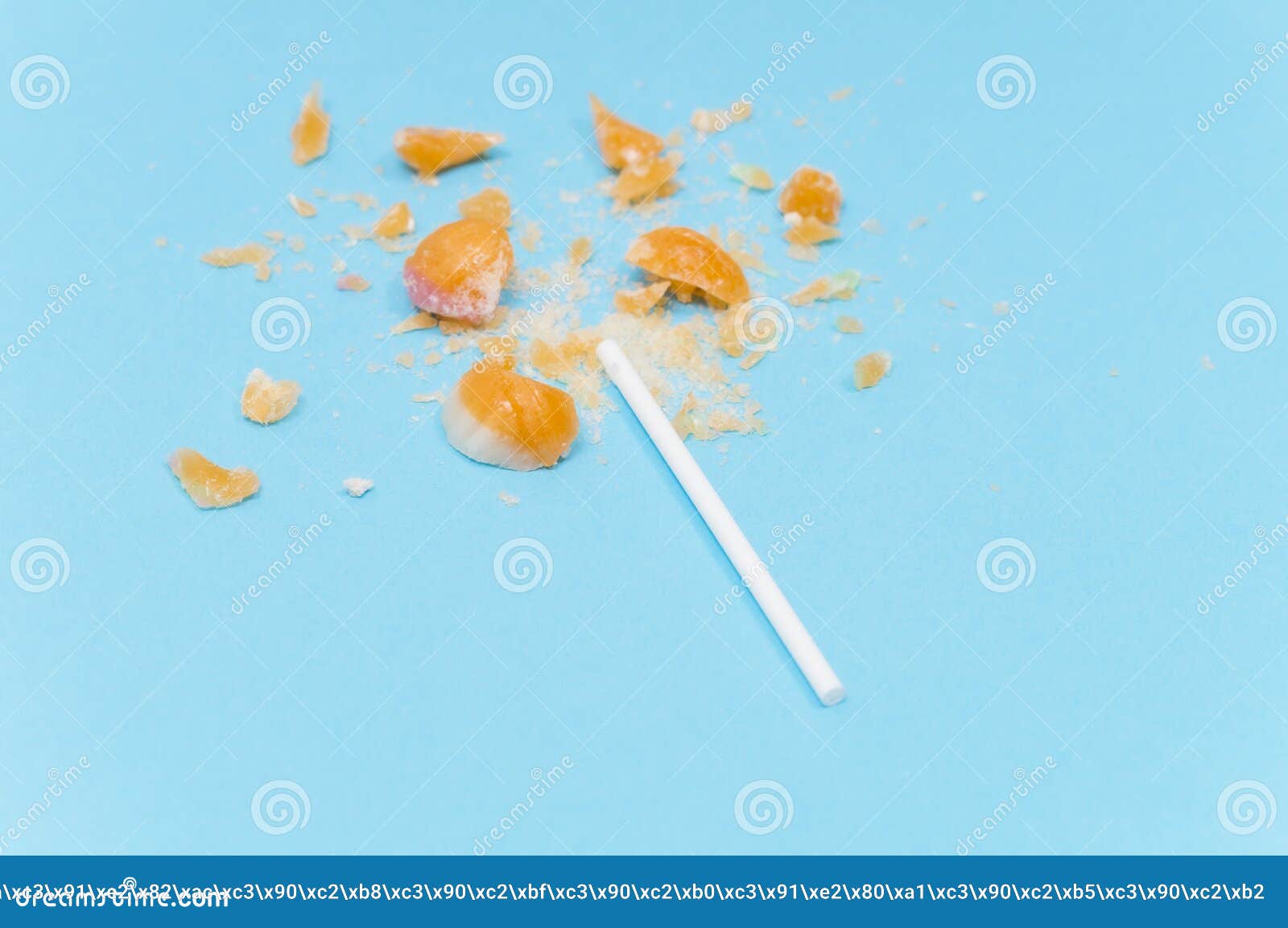 A Broken Lollipop on a Blue Background with a White Plastic Handle ...