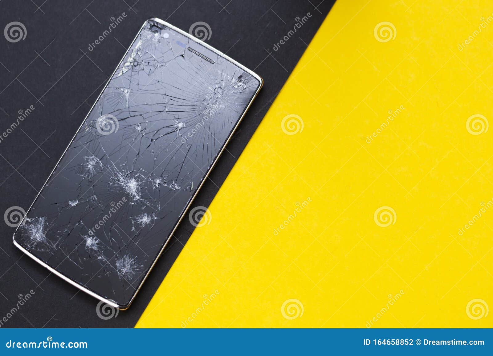 A Broken Phone on Yellow and Black Background. Crushed Device with ...