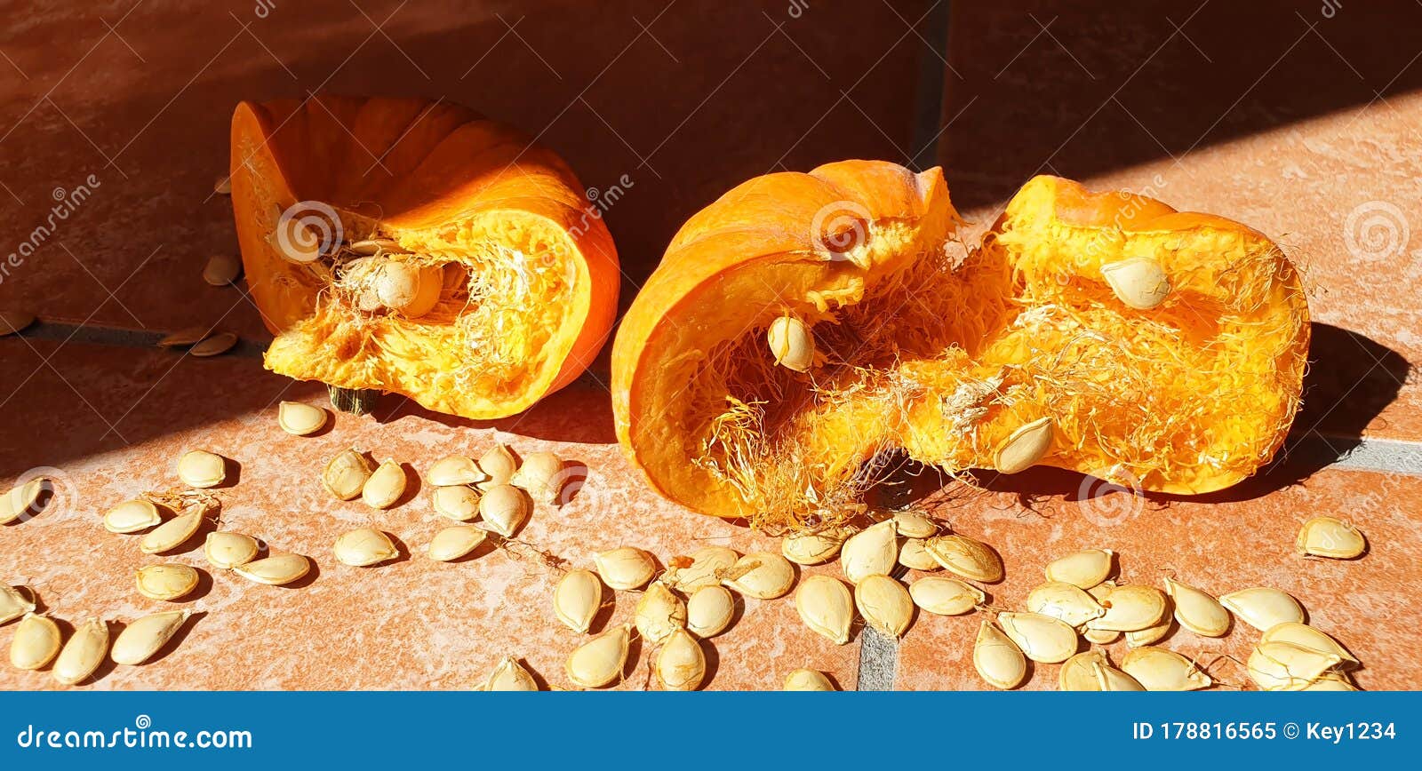Broken Pumpkin in Half with Scattered Seeds on the Stone Surface in the ...