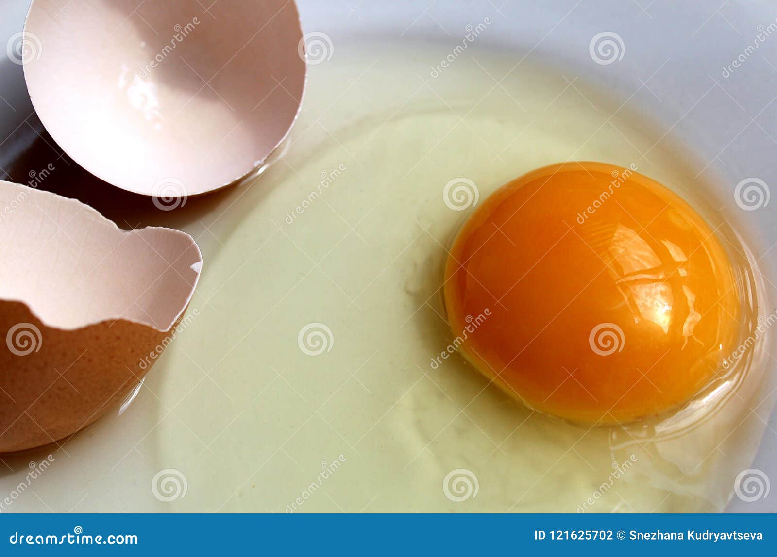 A Broken Raw Egg with a Shell Lies on a Plate Stock Photo - Image of ...