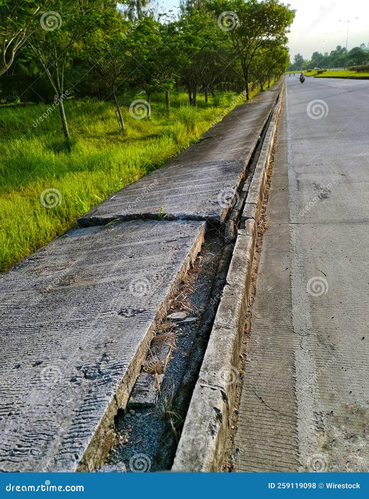 Broken Sidewalk on the Left Side of the Road is Broken with Green Lawn ...