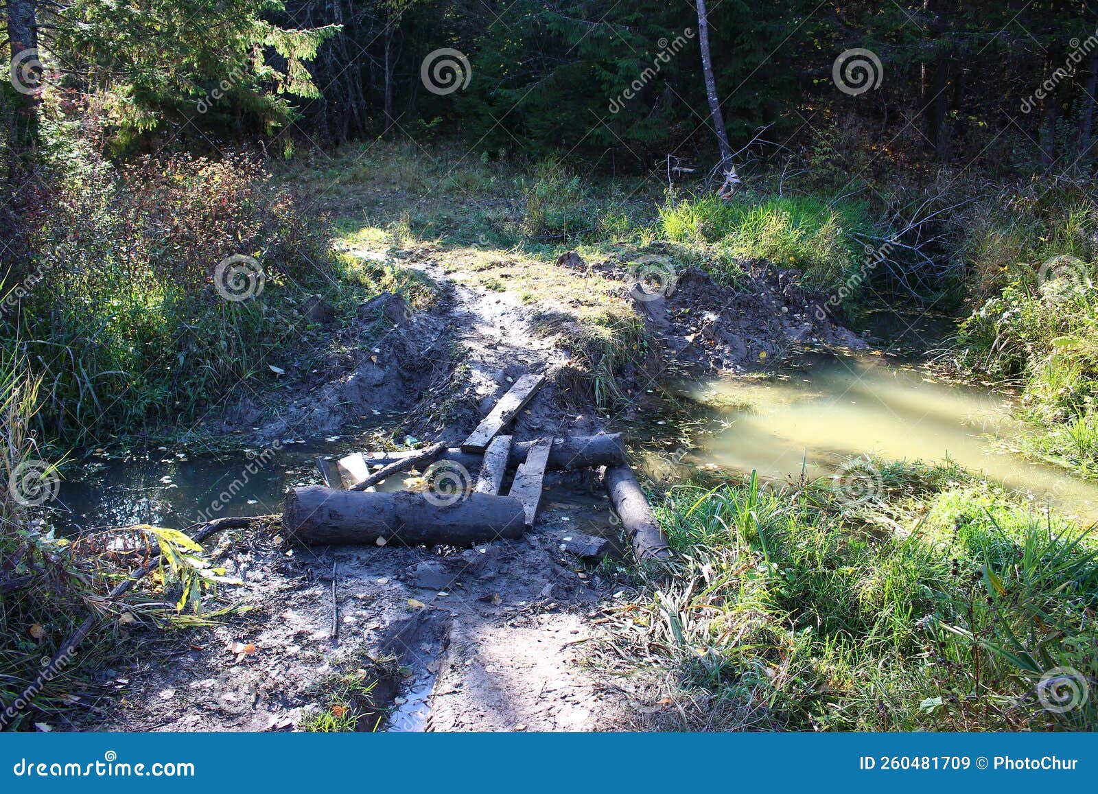 Broken Small Bridge Over a Muddy Stretch of Road with a Large Puddle ...