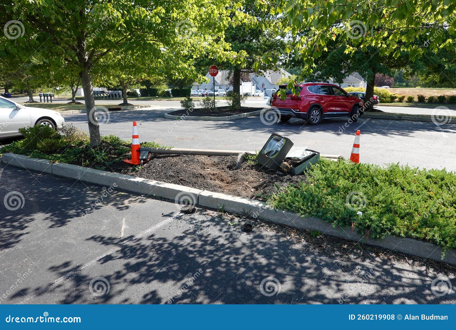 A Broken Street Light Lays on the Ground with Orange Warning Cones ...