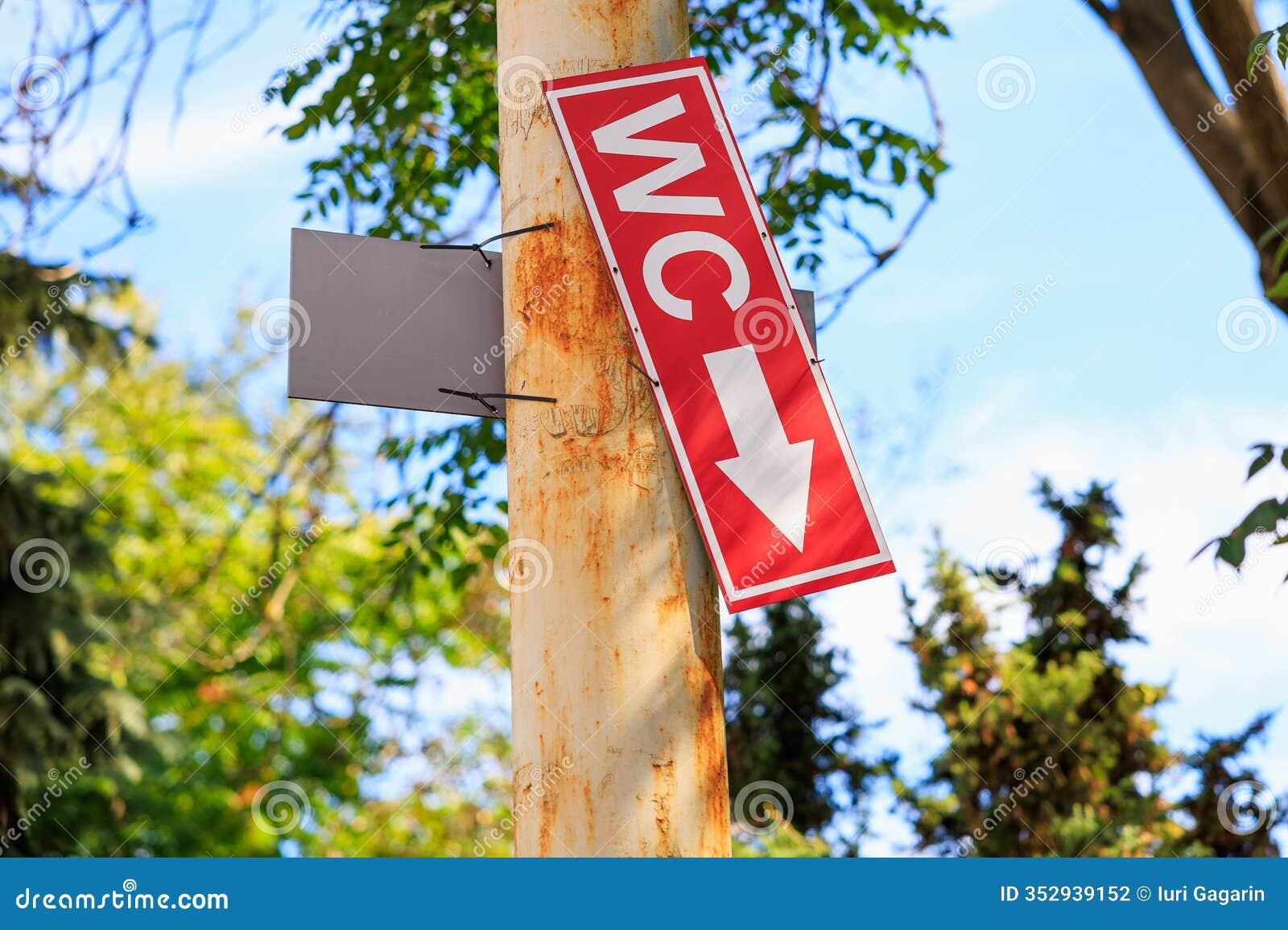 A Broken WC Sign Points Down a Pillar. Background with Selective Focus ...