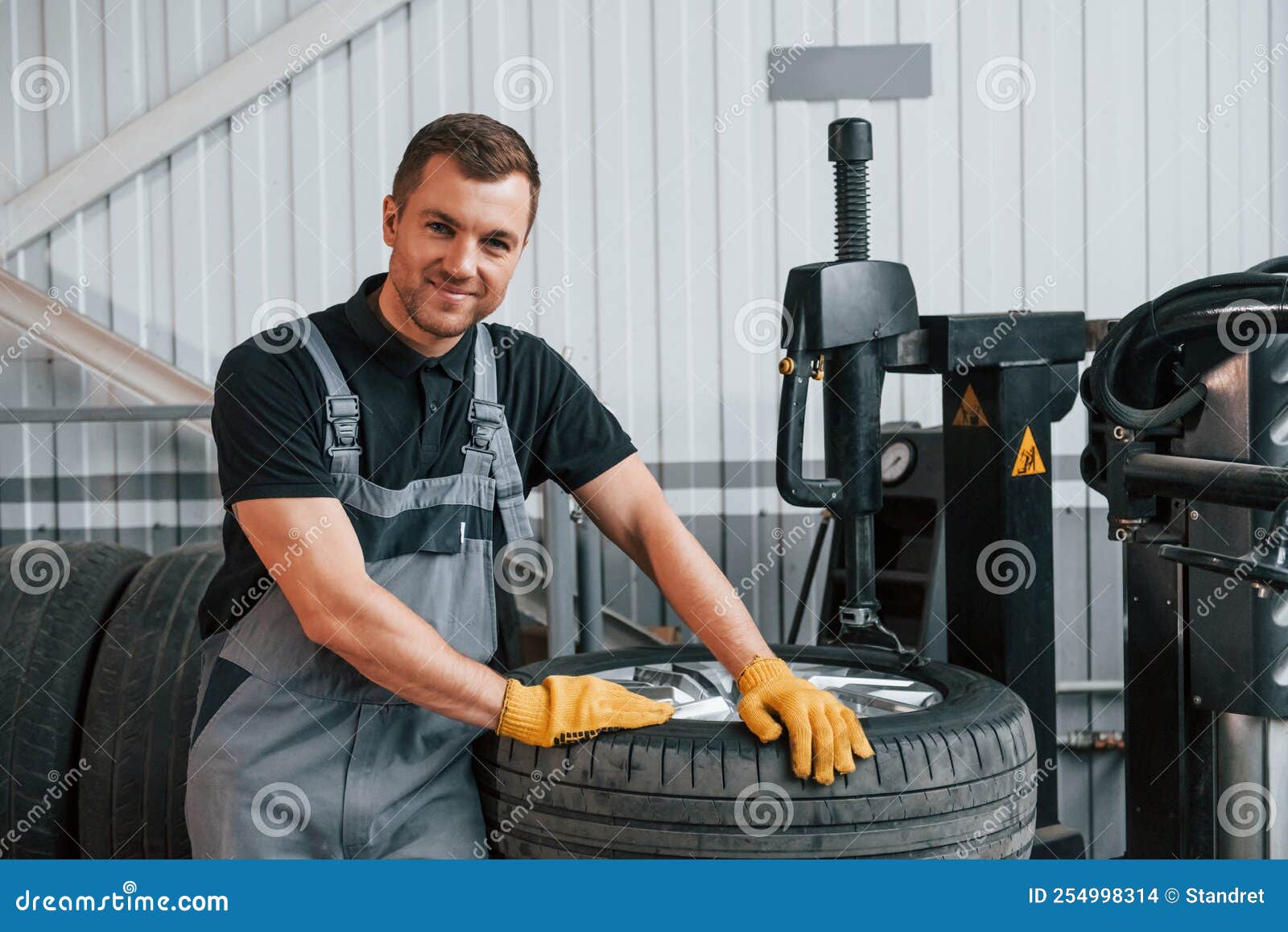 Broken Wheel. Man in Uniform is Working in the Auto Service Stock Photo ...