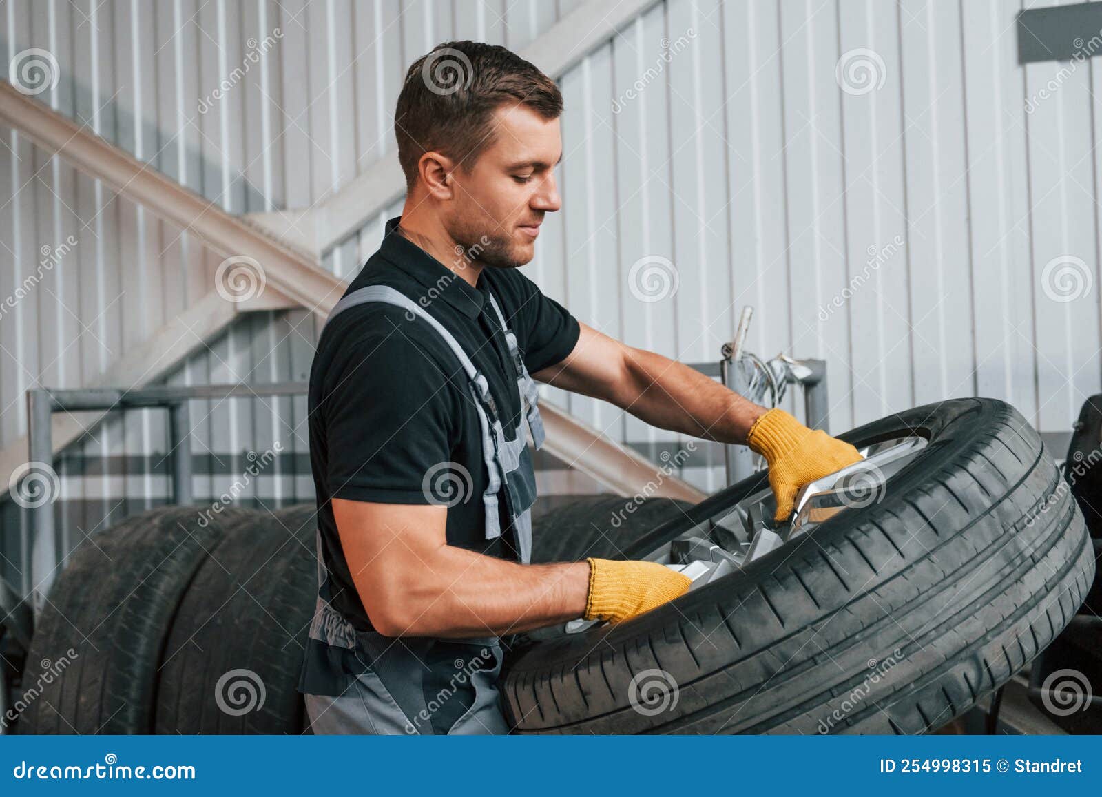 Broken Wheel. Man in Uniform is Working in the Auto Service Stock Image ...