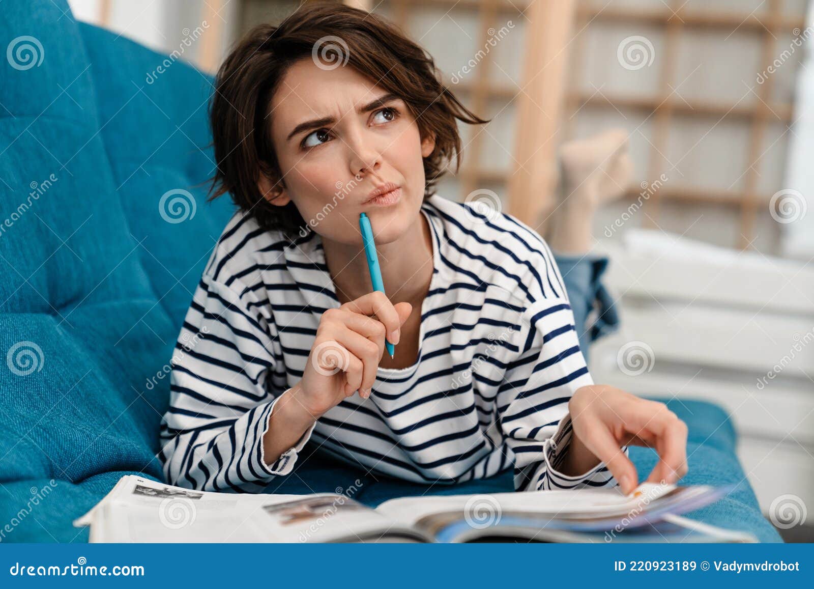 Brooding Beautiful Student Girl Doing Homework while Lying on Couch ...