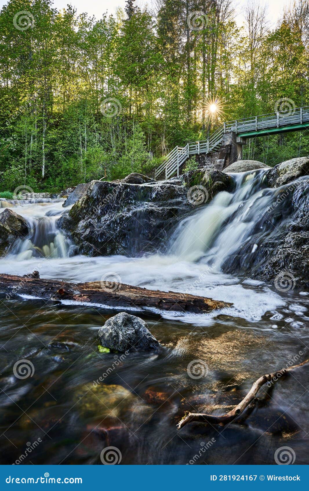 Brook Cascading Down Rocks with a Wooden Bridge Visible in the Distance. Stock Image - Image of ...