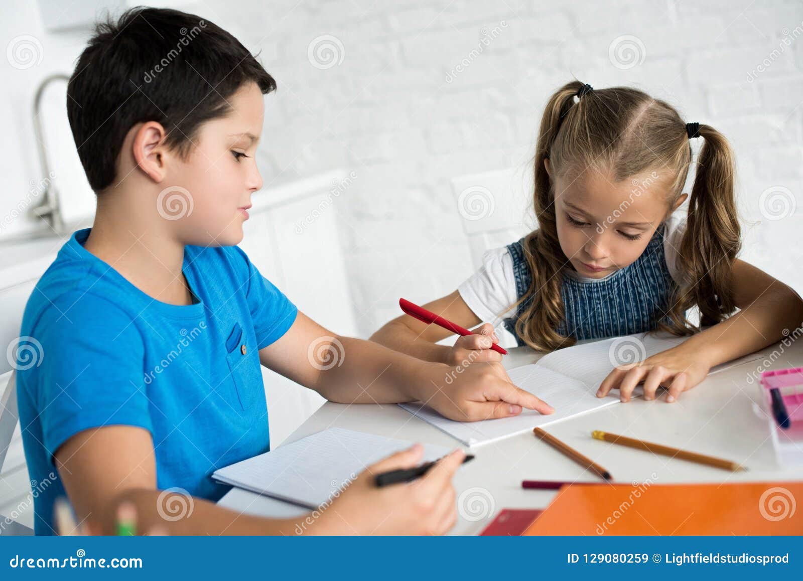 Brother and Sister Doing Homework Together at Table Stock Image - Image ...