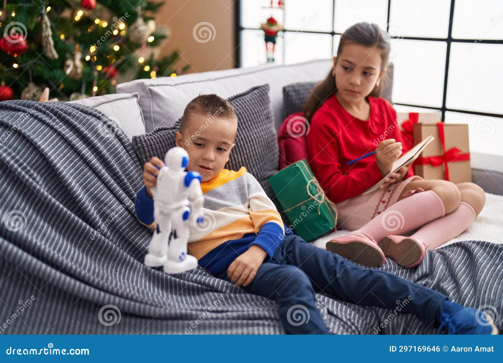 Brother and Sister Playing with Robot and Writing on Notebook Sitting ...