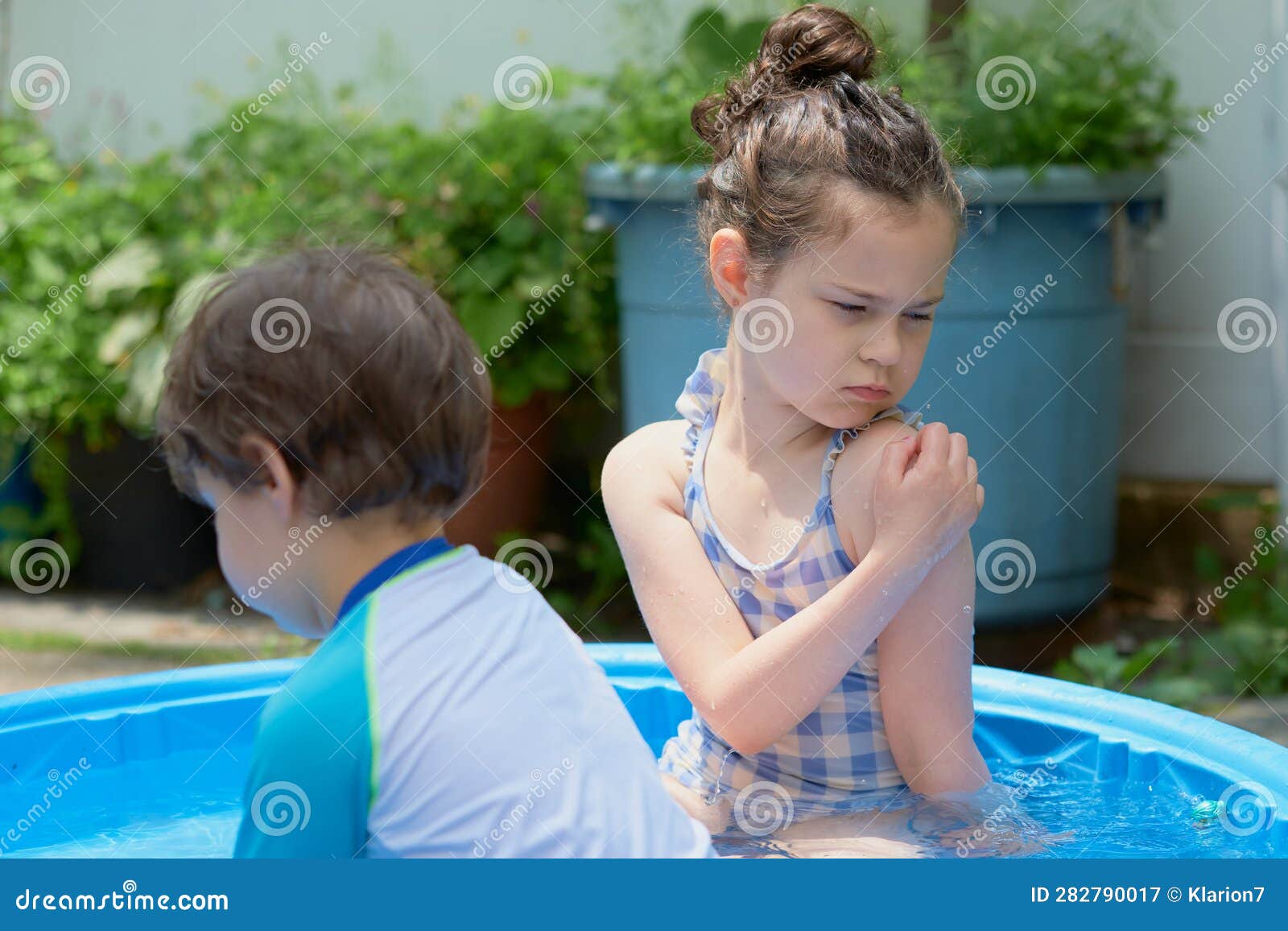 Brother and Sister Playing in a Shallow Pool in the Backyard Stock ...