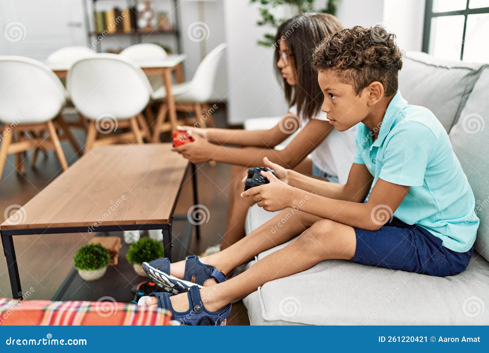 Brother and Sister Playing Video Game Sitting on Sofa at Home Stock ...
