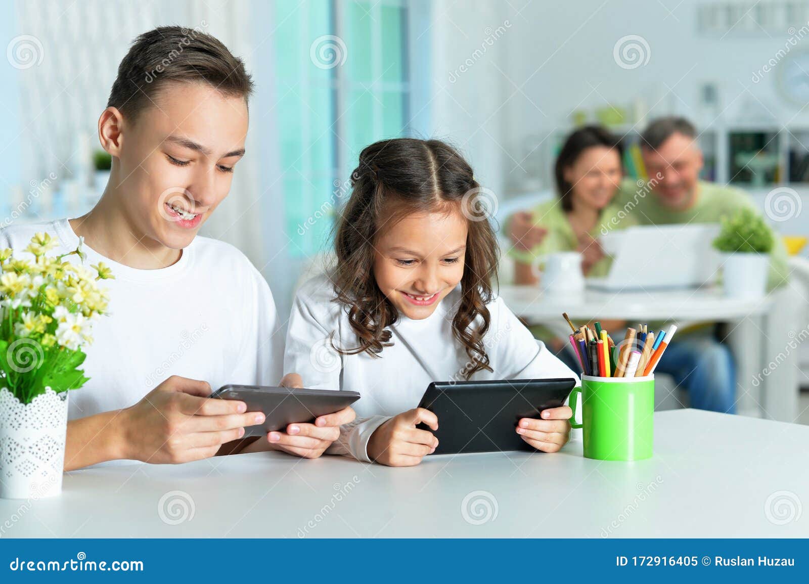 Brother and Sister Sitting at Table and Using Digital Devices Stock ...