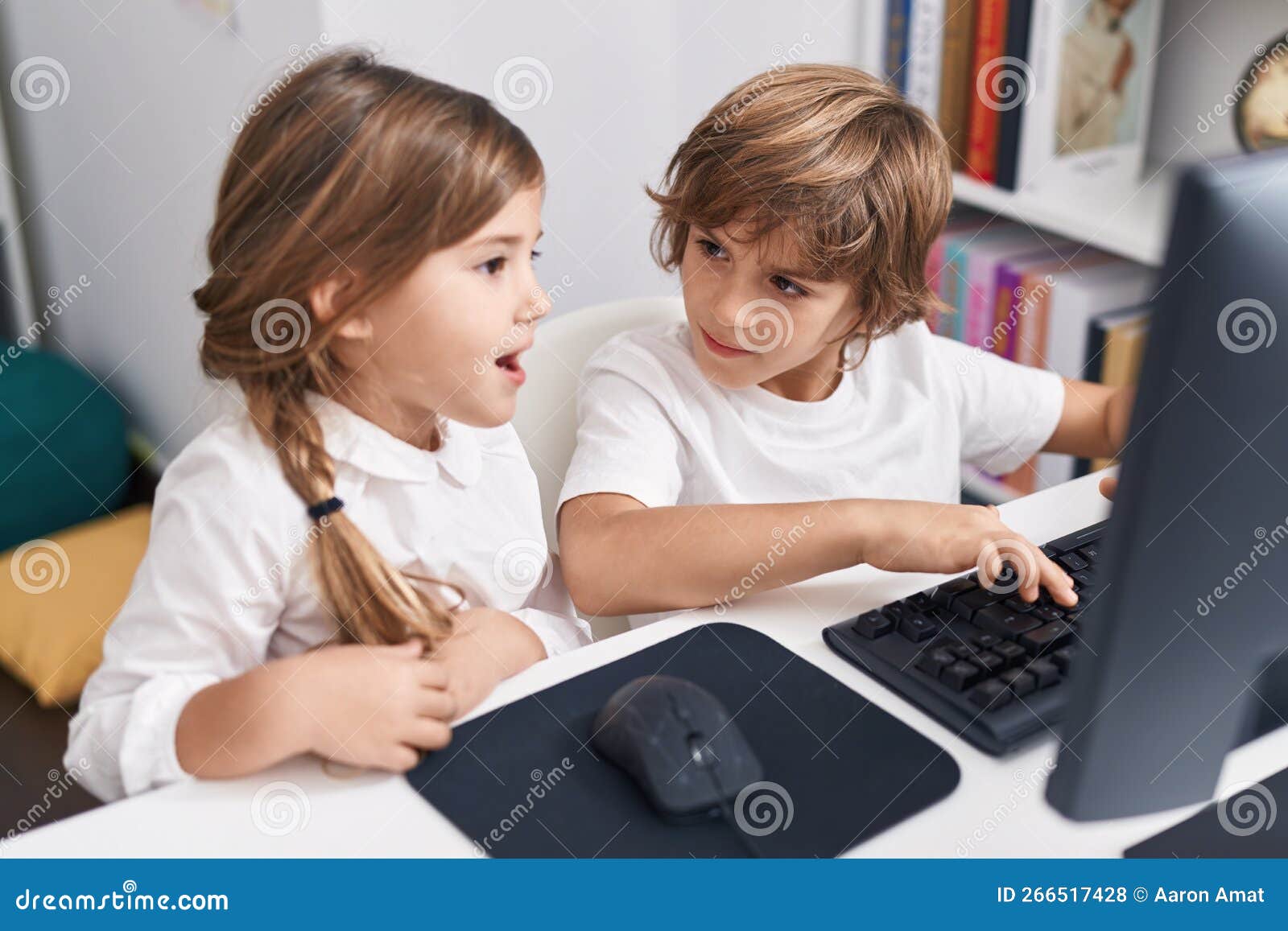 Brother and Sister Students Using Computer Sitting on Table at ...