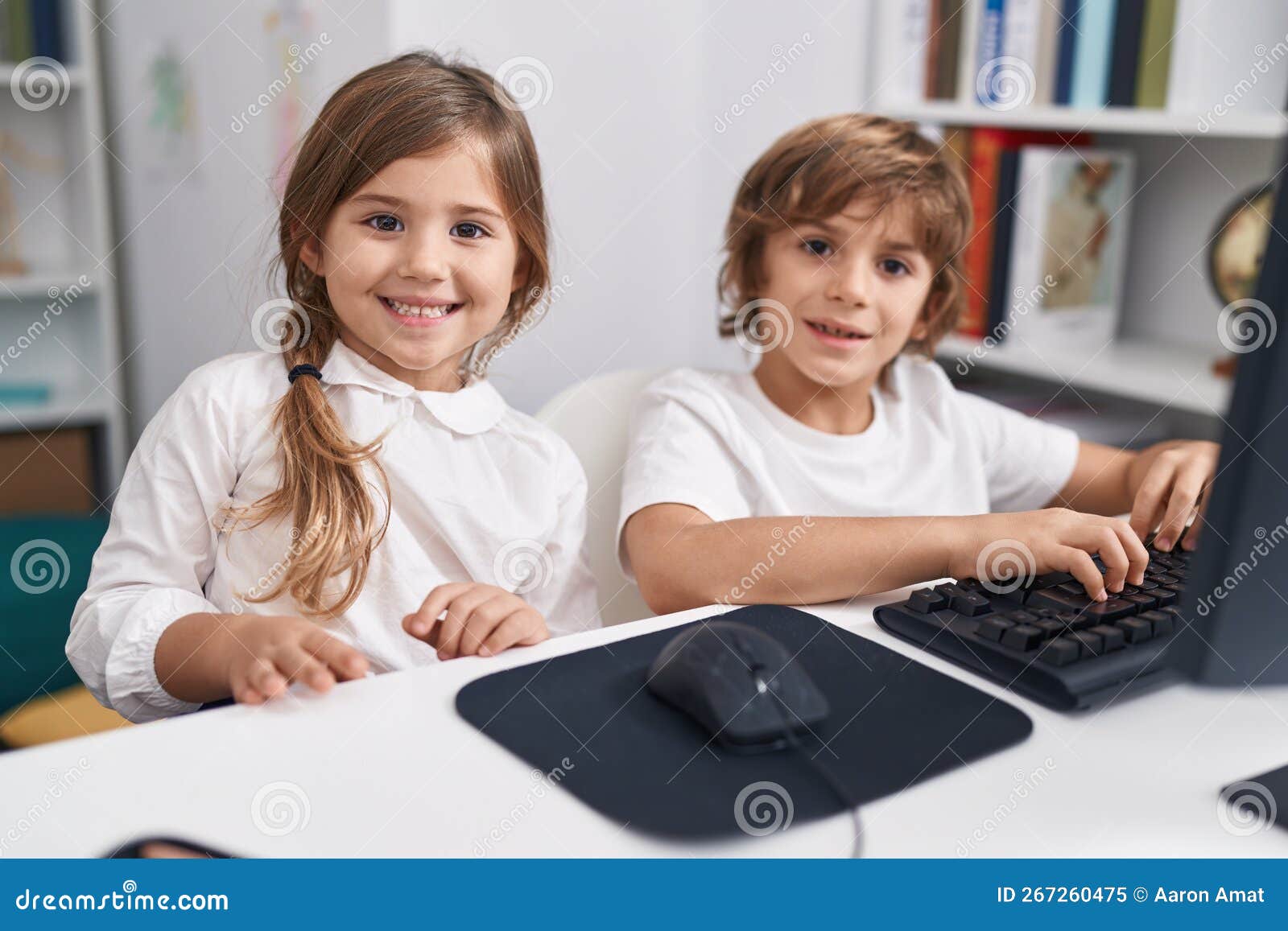 Brother and Sister Students Using Computer Sitting on Table at ...