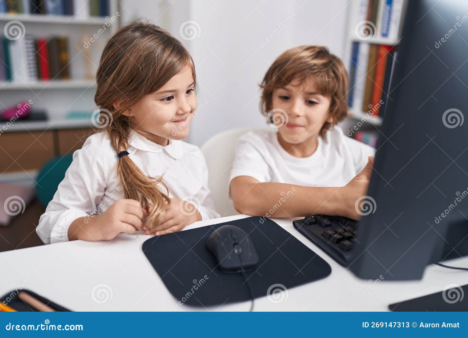 Brother and Sister Students Using Computer Sitting on Table at ...