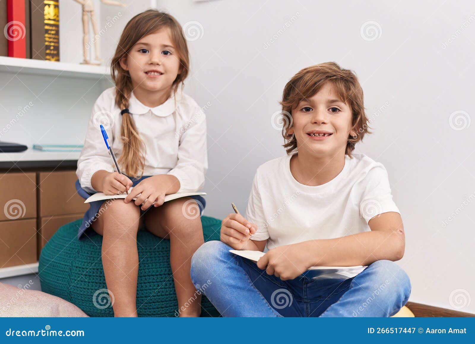 Brother and Sister Students Writing on Notebook Studying at Library ...