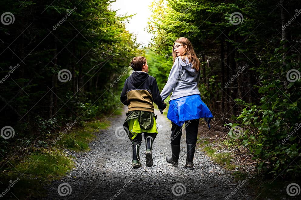 Brother And Sister Walking Hand In Hand Under Sunset Sky On A Gravel Road Editorial Photo