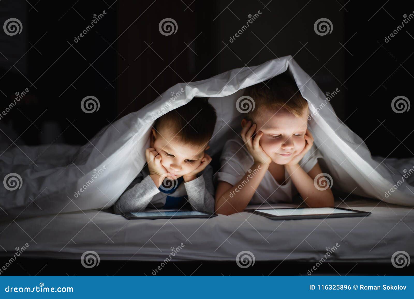 Two Kids Using Tablet Pc Under Blanket at Night. Stock Photo - Image of ...