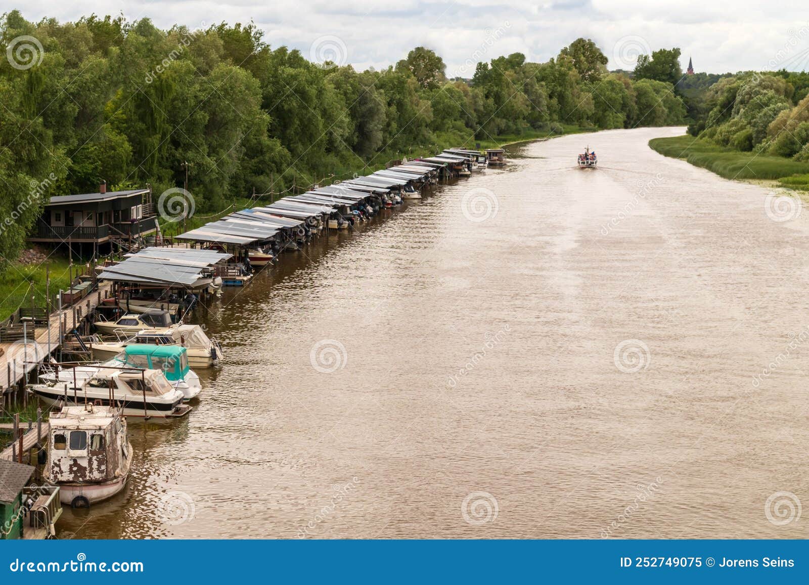 A Brown Colored River with Cutters in the Harbor Along the Edge of the ...