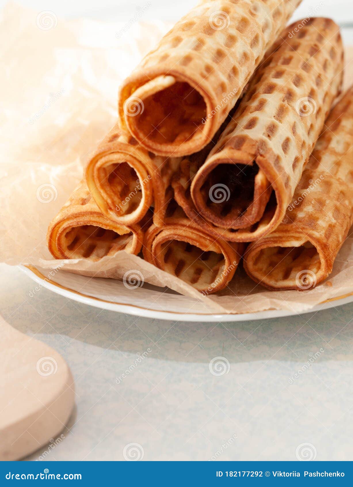 Brown Crispy Rolled Waffles in Stack on Parchment Paper and White Plate ...