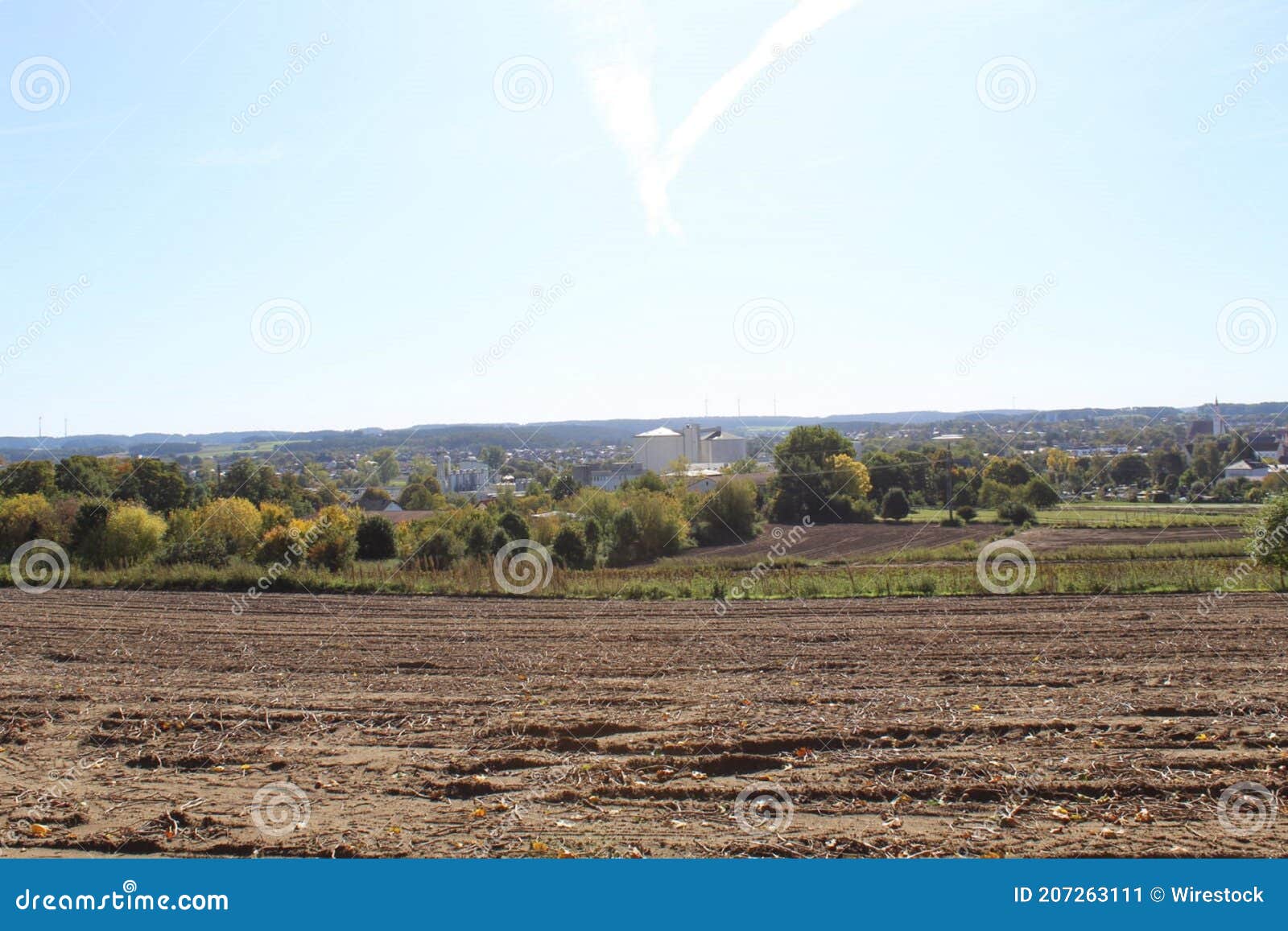 Brown Cropland with Green Trees and a Clear Sky in the Background Stock ...