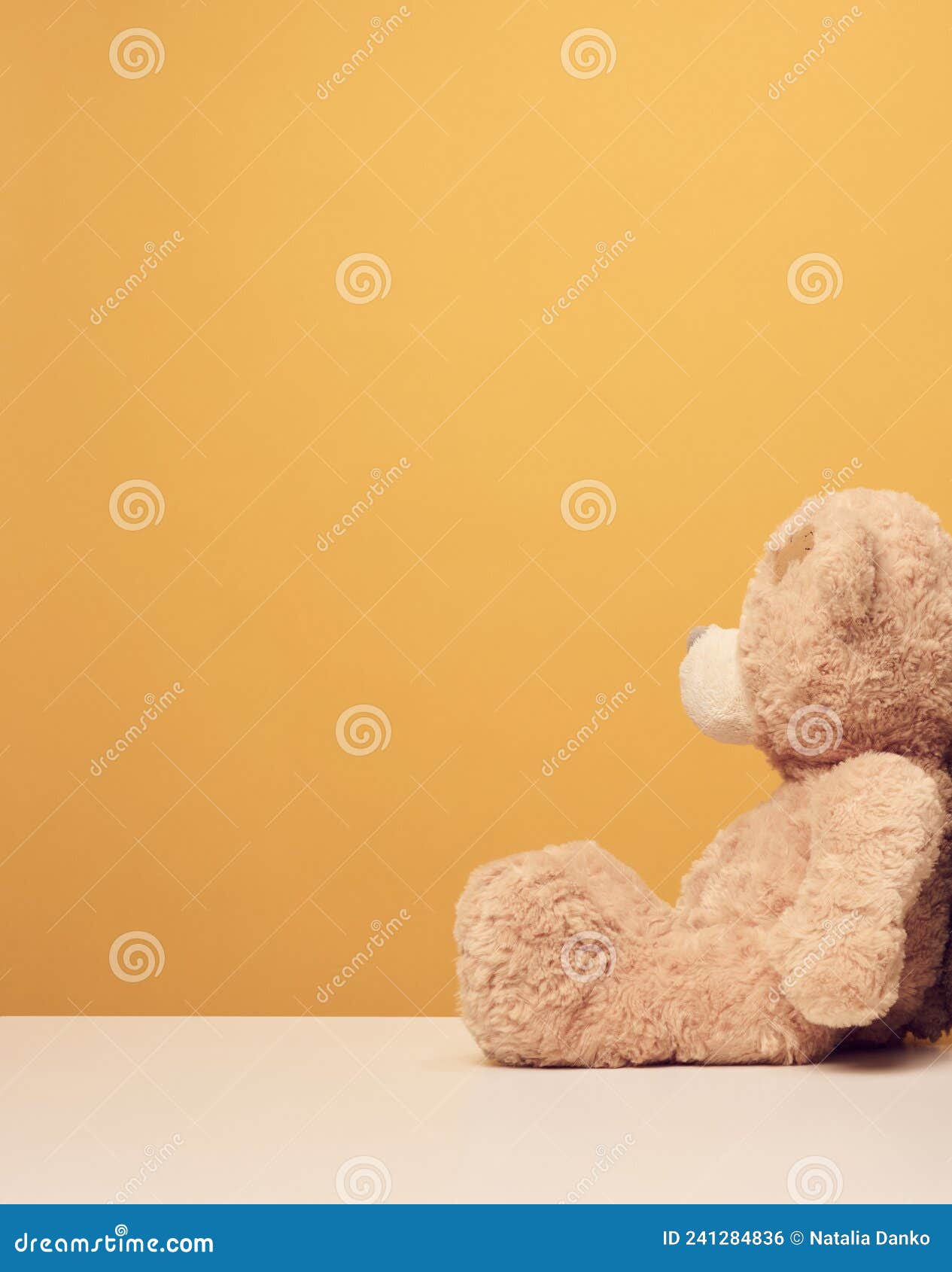 Brown Cute Teddy Bear Sits Sideways on Yellow Background, Sadness Stock ...