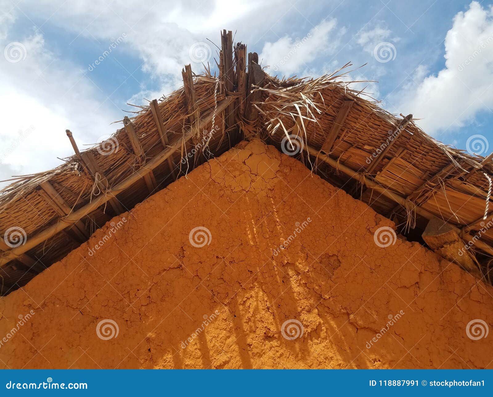 Brown and Red Side of Adobe Building with Straw Roof Stock Image ...