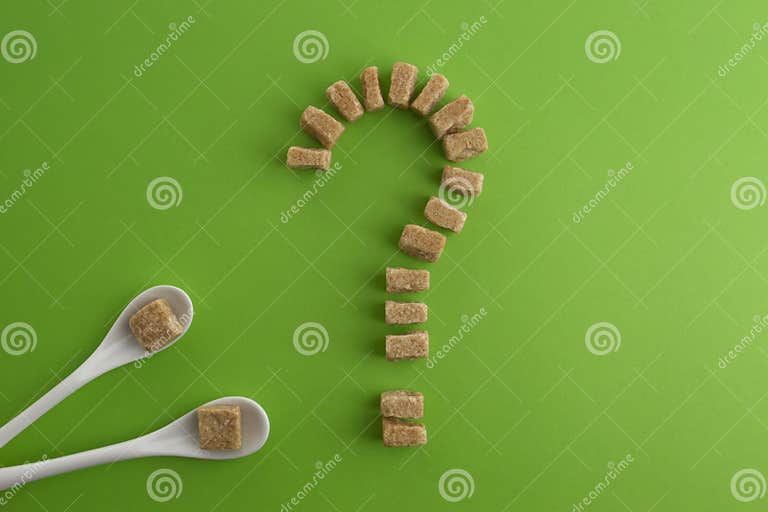 Brown Sugar Cubes Shaped As A Question Mark On Greenery Background Top View Diet Unhealty
