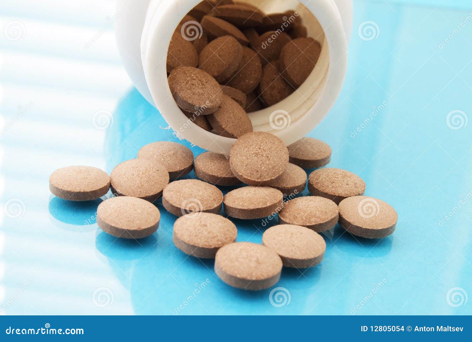 Brown Tablets Falling Out Of An Open Package On A Dark Mirror ...