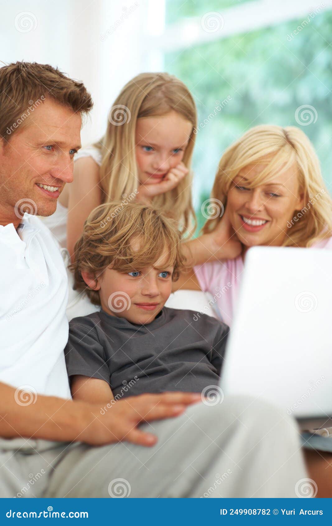 Browsing the Web Together. Happy Young Family Using a Laptop Together ...