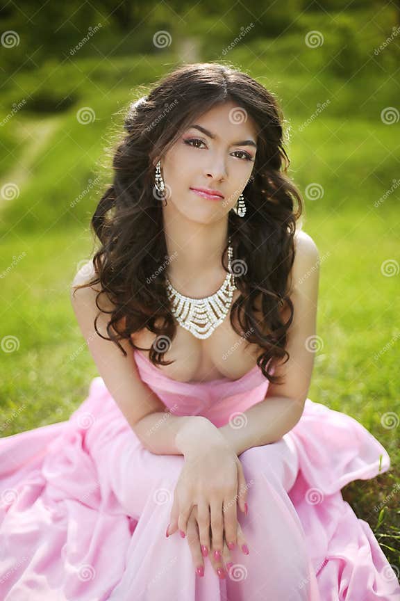 Brunette Bride In Pink Wedding Dress Resting And Sitting On Green Grass