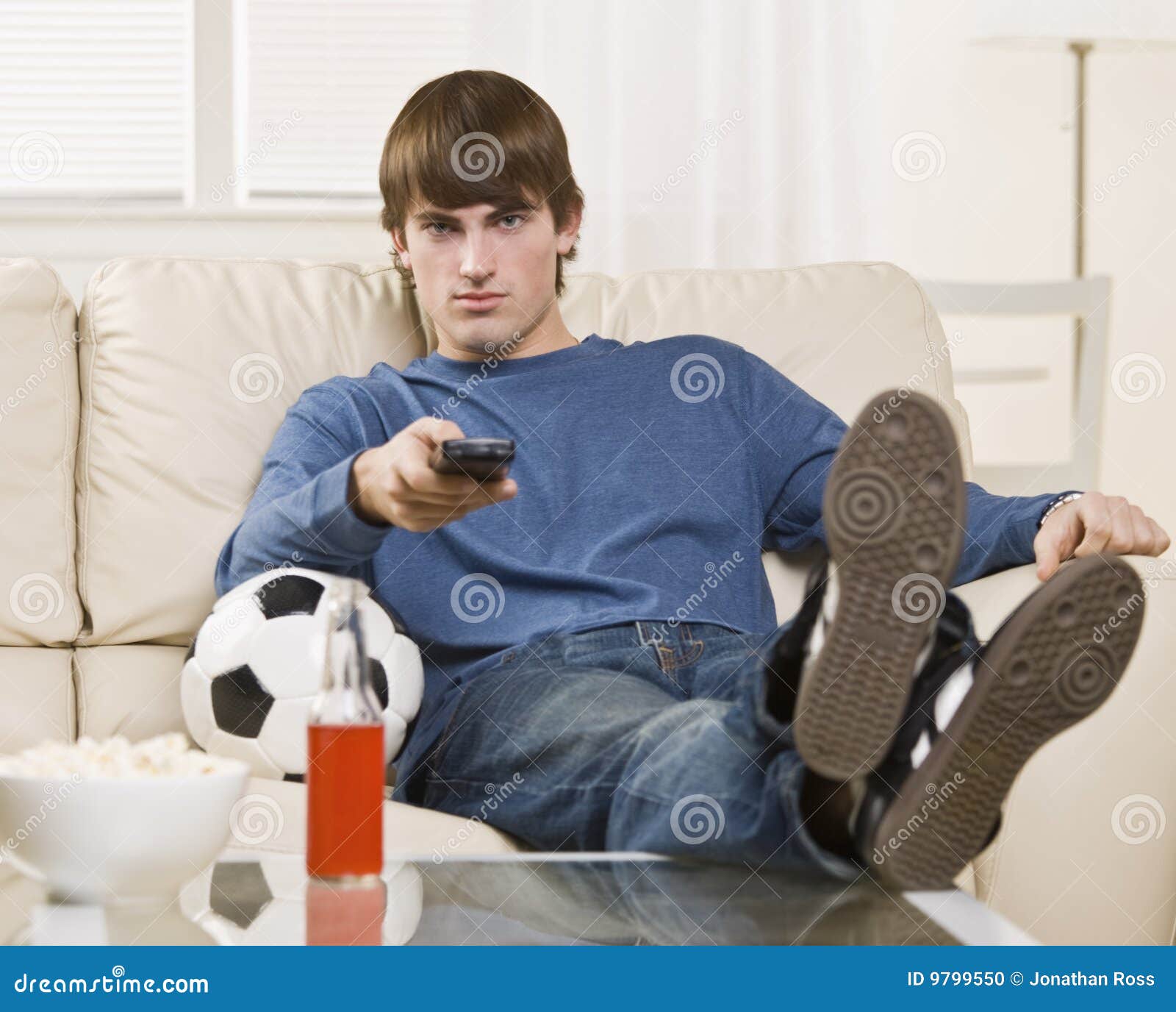 Brunette guy watching TV stock photo. Image of calm, living - 9799550