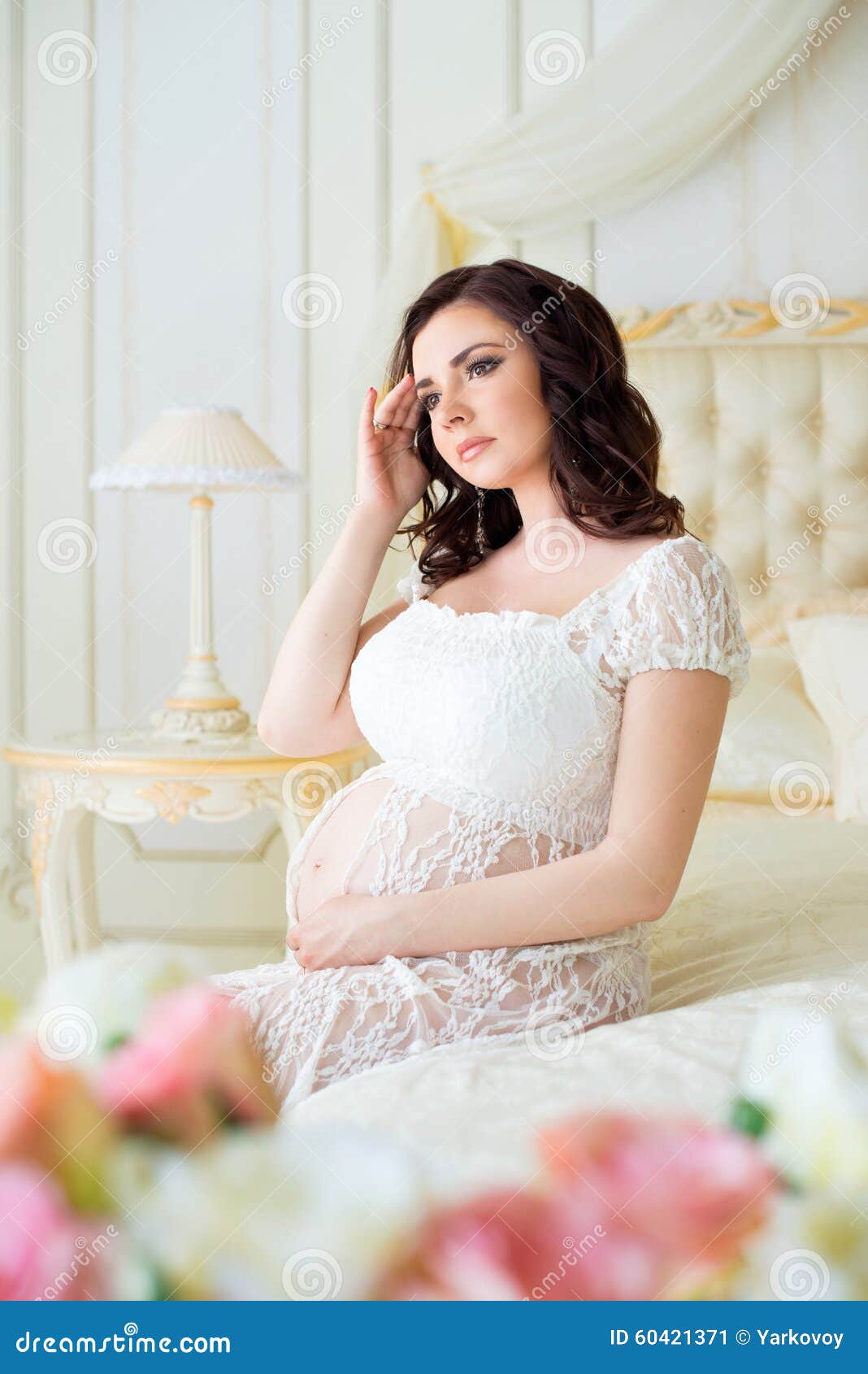 Brunette Pregnant Young Woman Sits In A Beautiful Interior With Roses