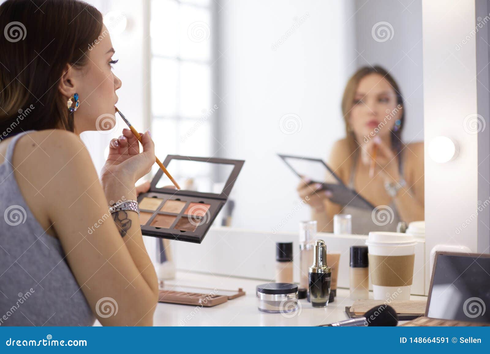 Brunette Woman Applying Make Up for a Evening Date in Front of a Mirror ...