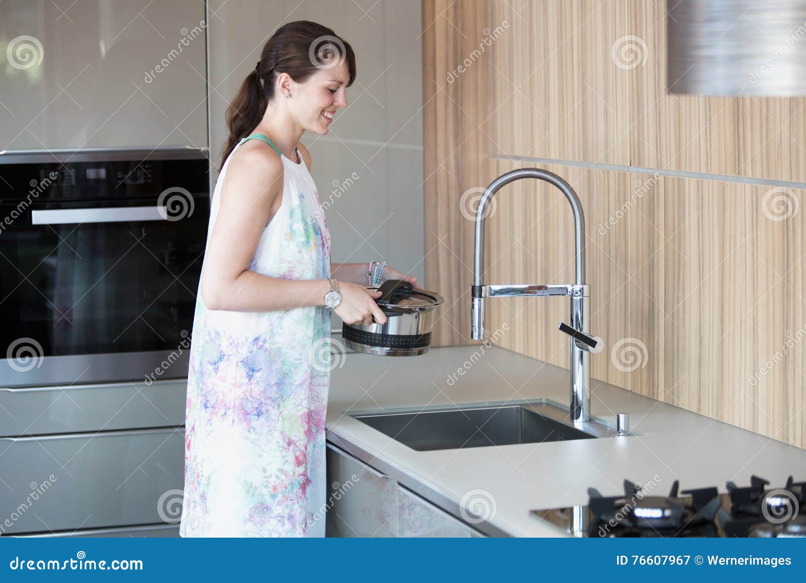 Brunette Woman Holding Pot Over Kitchen Sink Stock Image - Image of ...