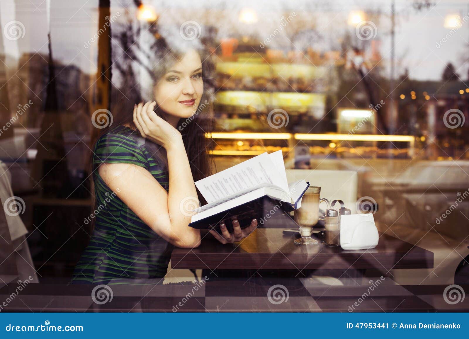 Brunette Woman Sitting at the Cafe Reading Book, Studing and Drinking ...