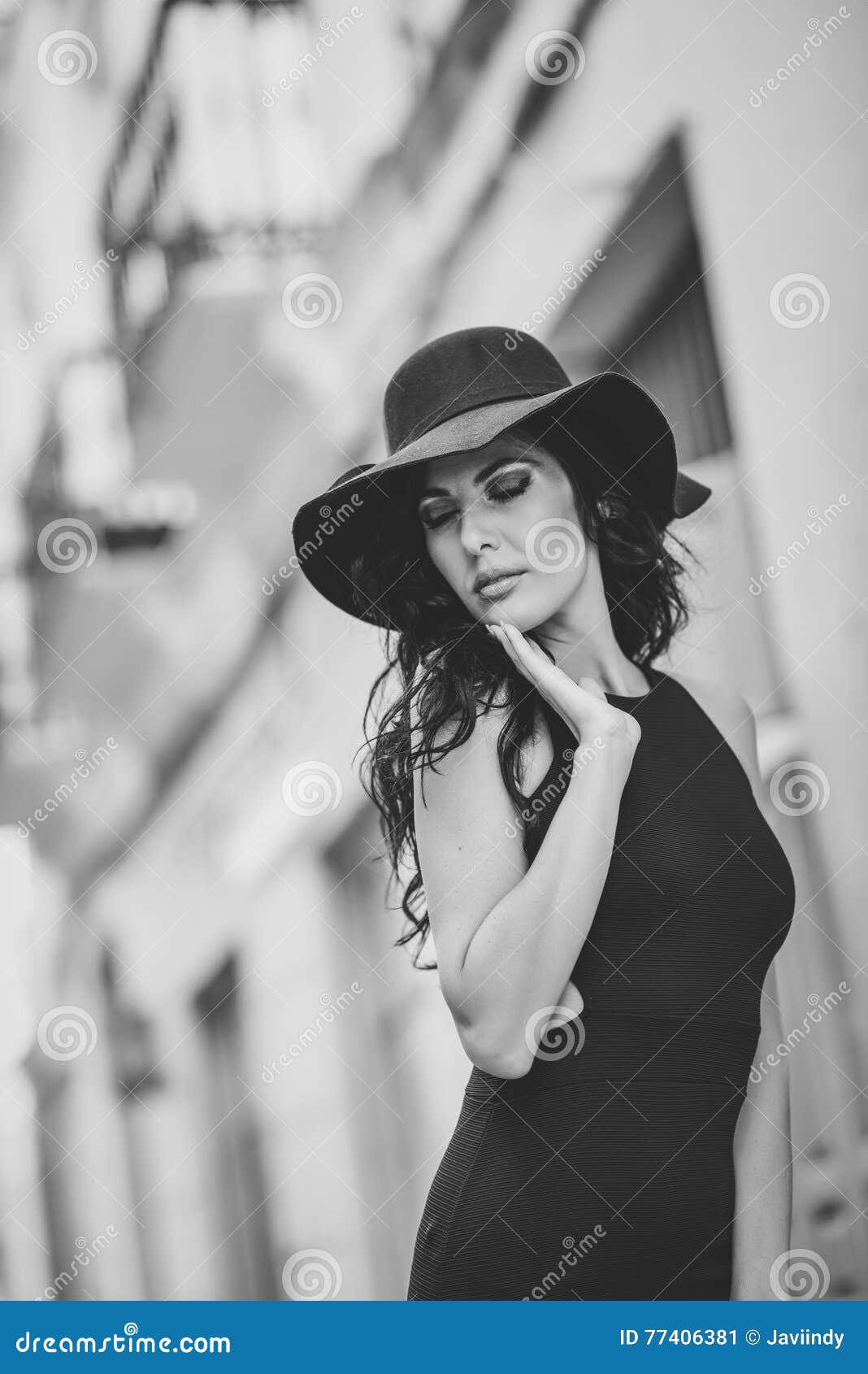 Brunette Woman Wearing Black Seductive Dress In The Street Stock Image