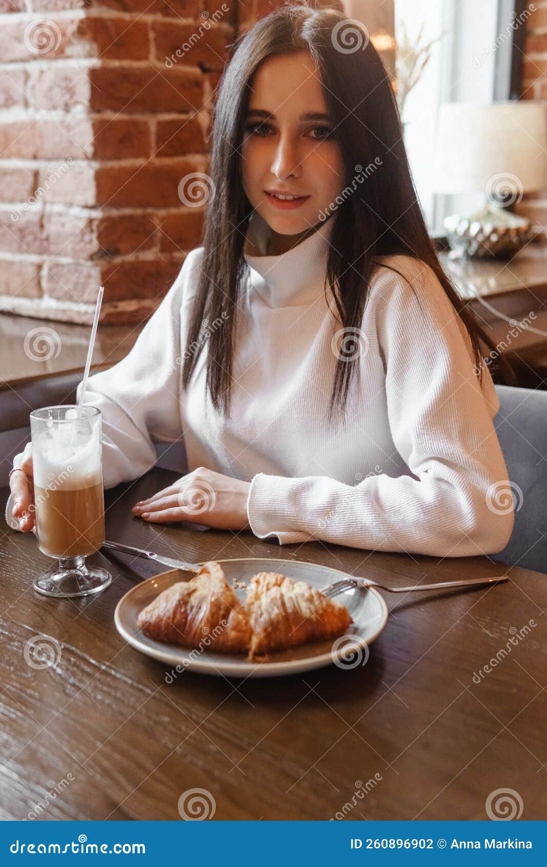 The Brunette is Working with a Tablet at a Table in a Cafe. Drinks ...