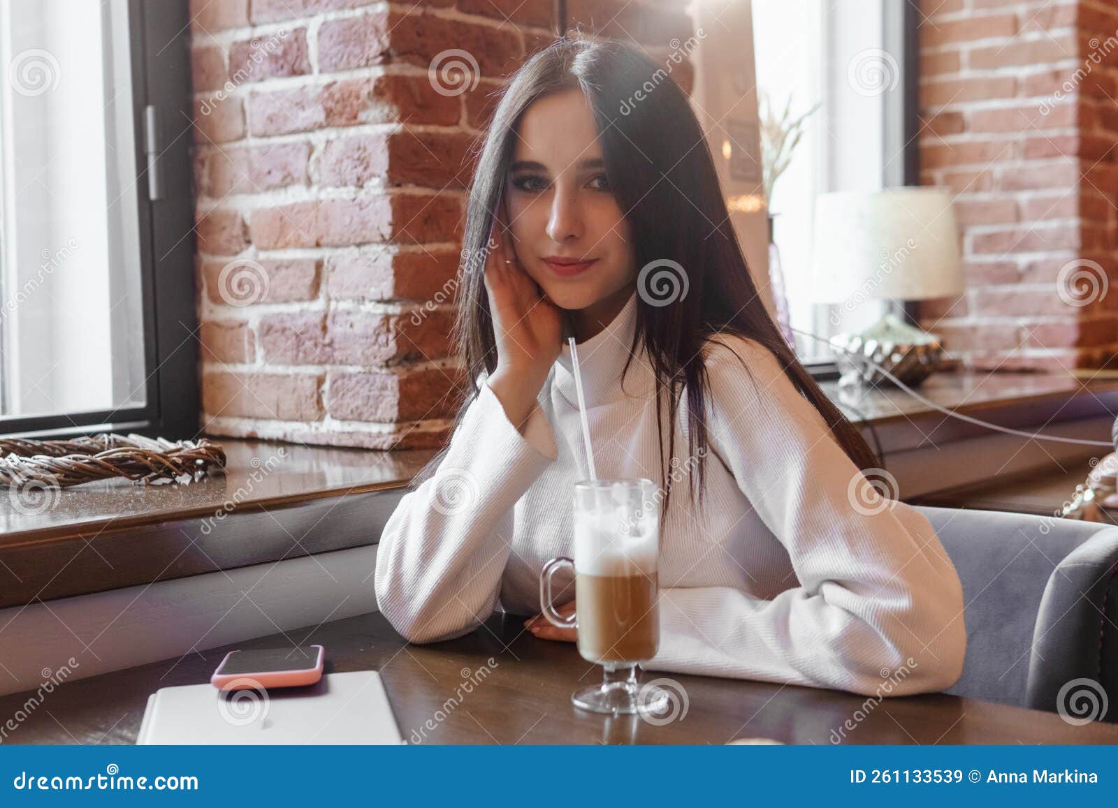 The Brunette is Working with a Tablet at a Table in a Cafe. Drinks ...