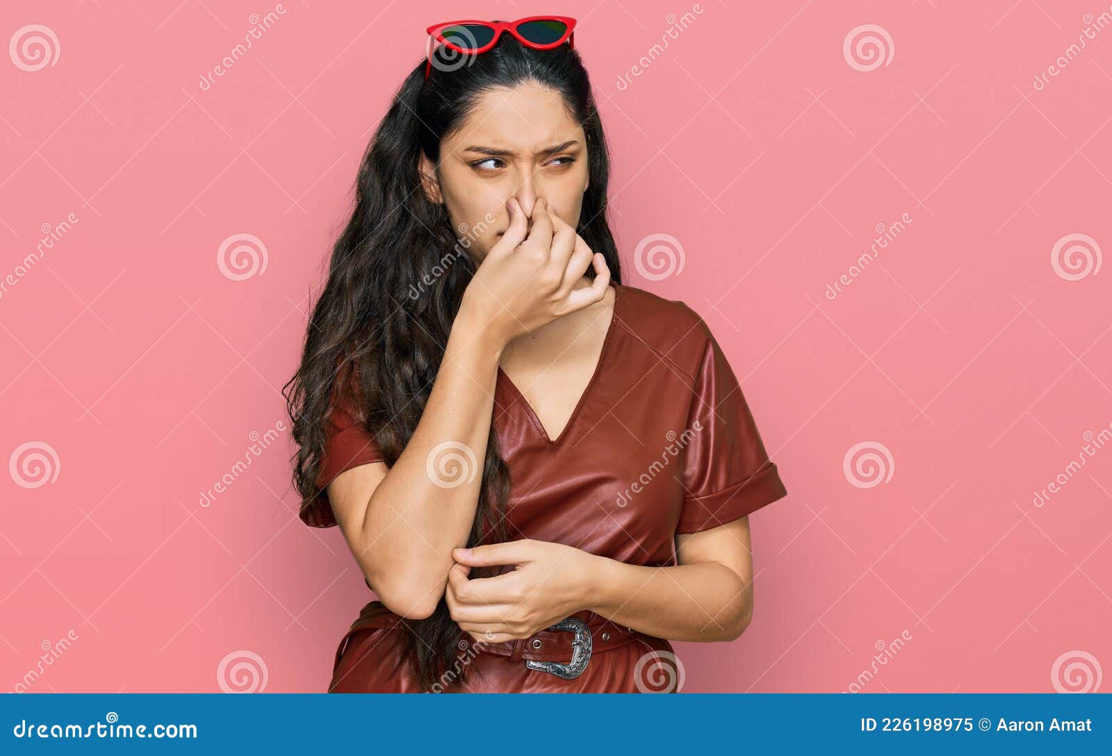 Brunette Young Woman Wearing Dress And Sunglasses Smelling Something